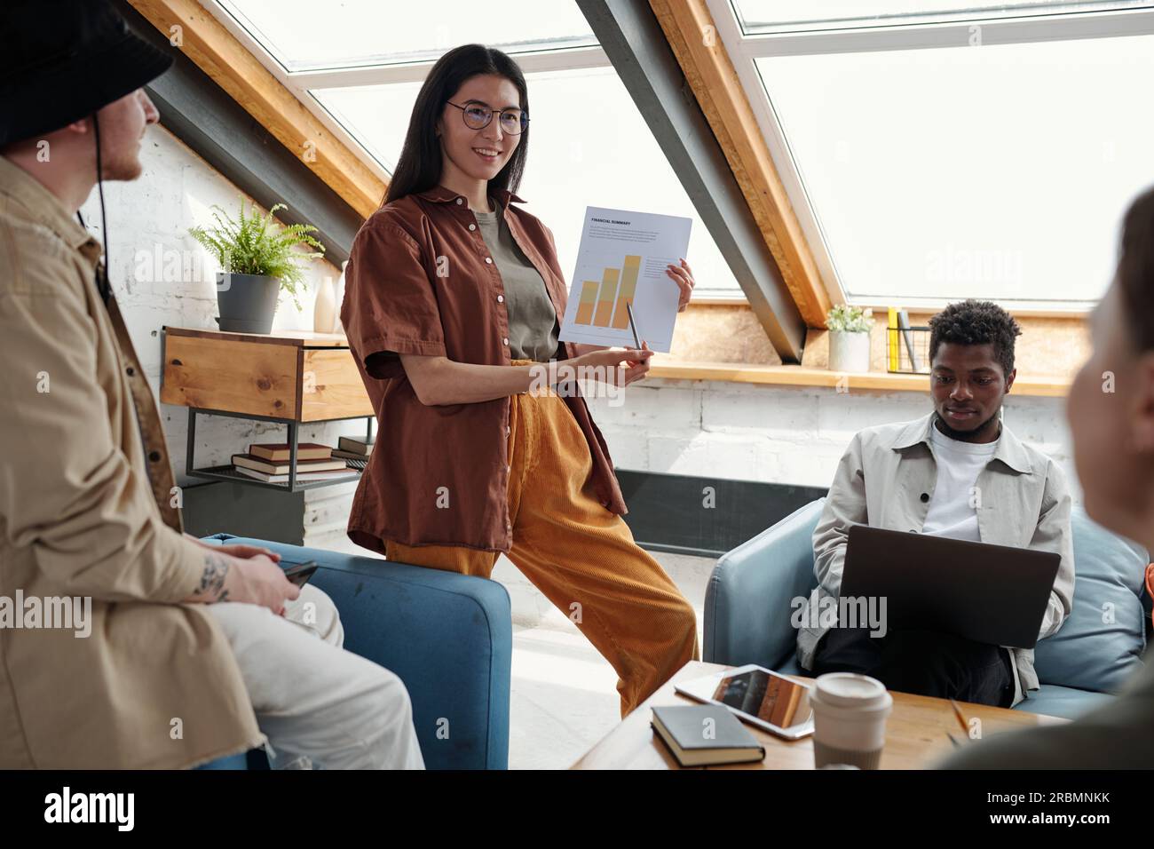 Young smilling female business coach pointing at document with ...