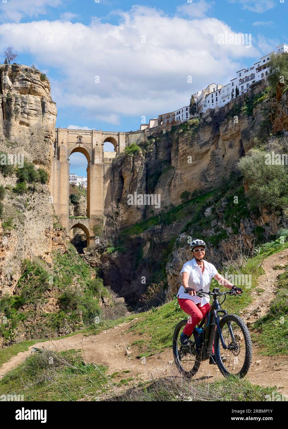 nice, active senior woman riding her electric mountain bike below the ...
