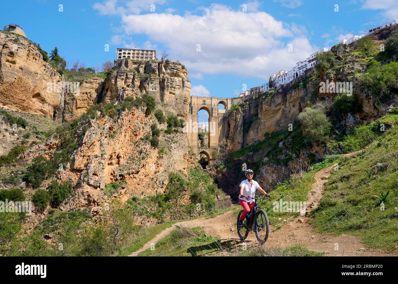 nice, active senior woman riding her electric mountain bike below the ...
