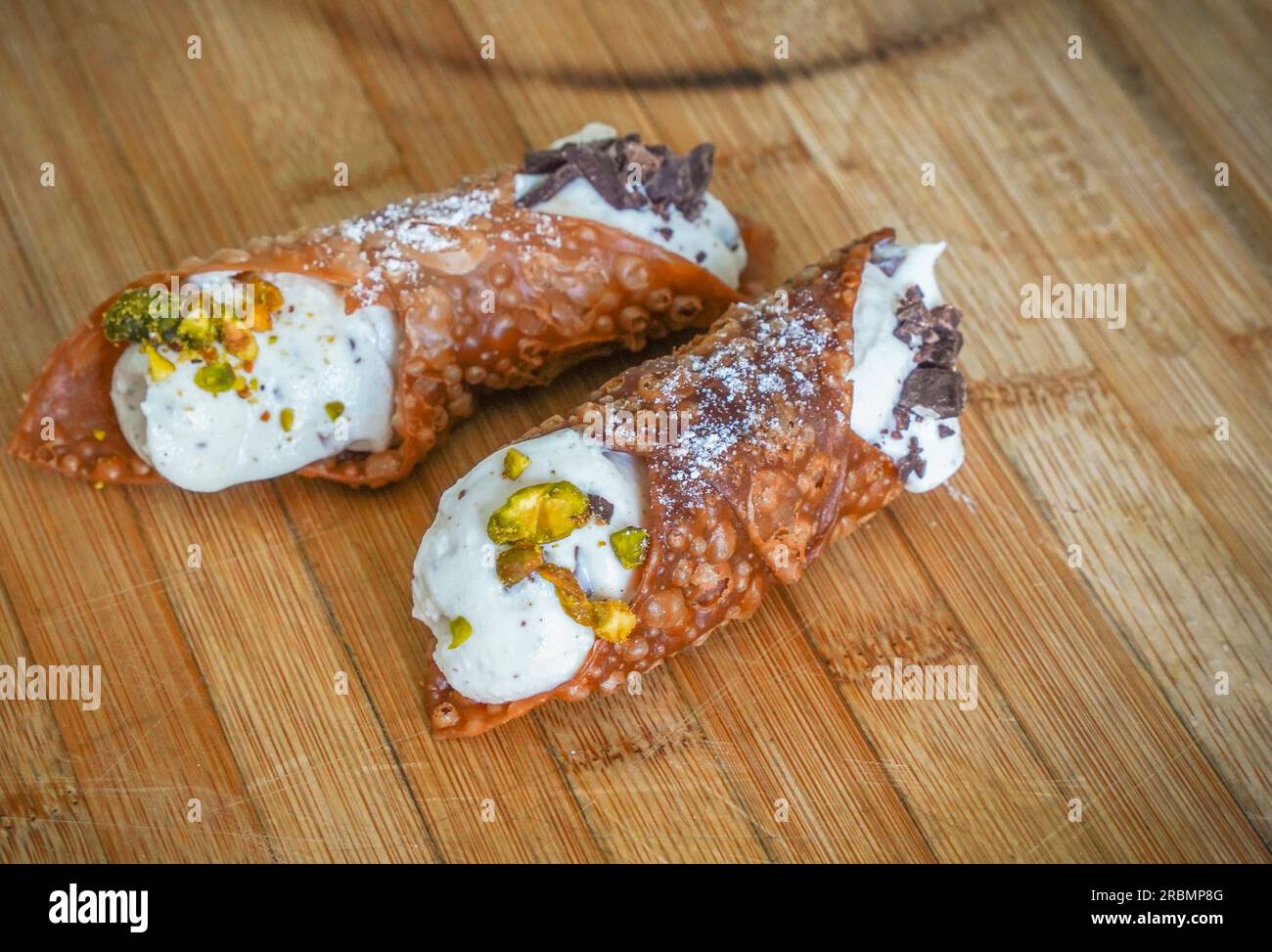 An Italian cannoli filled with ricotta cream on wooden board Stock ...