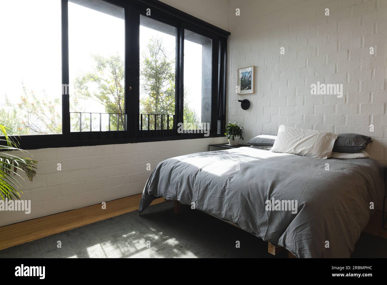 View of bright modern bedroom interior with double bed and large ...