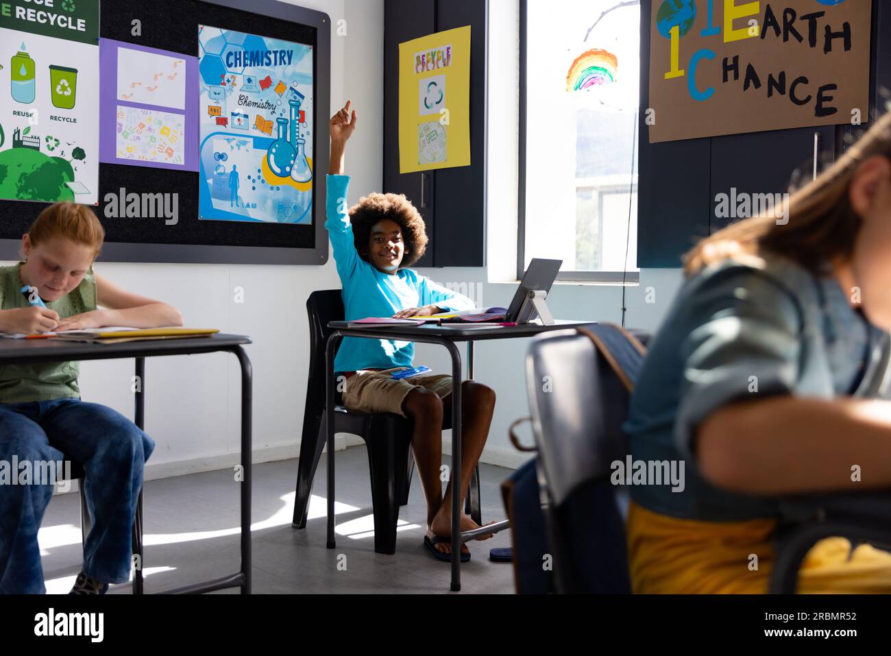 Happy diverse schoolchildren sitting at desks in school classroom Stock ...