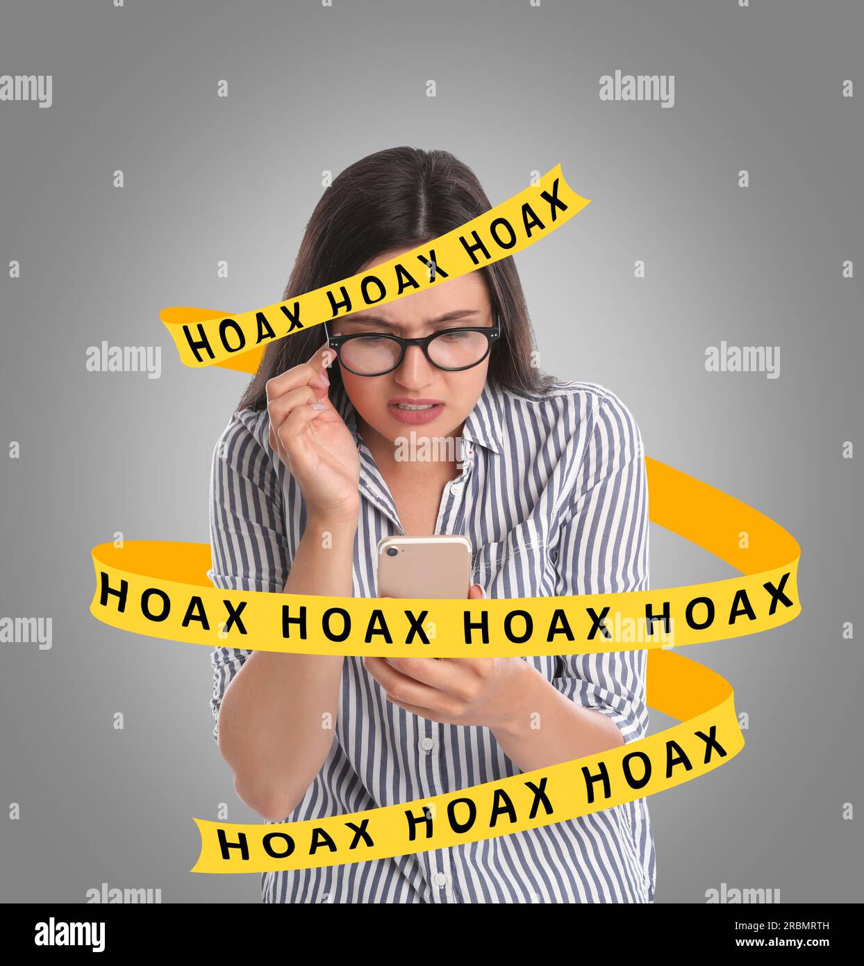 Information hygiene. Woman using mobile phone on grey background. Yellow tape with words Hoax ...