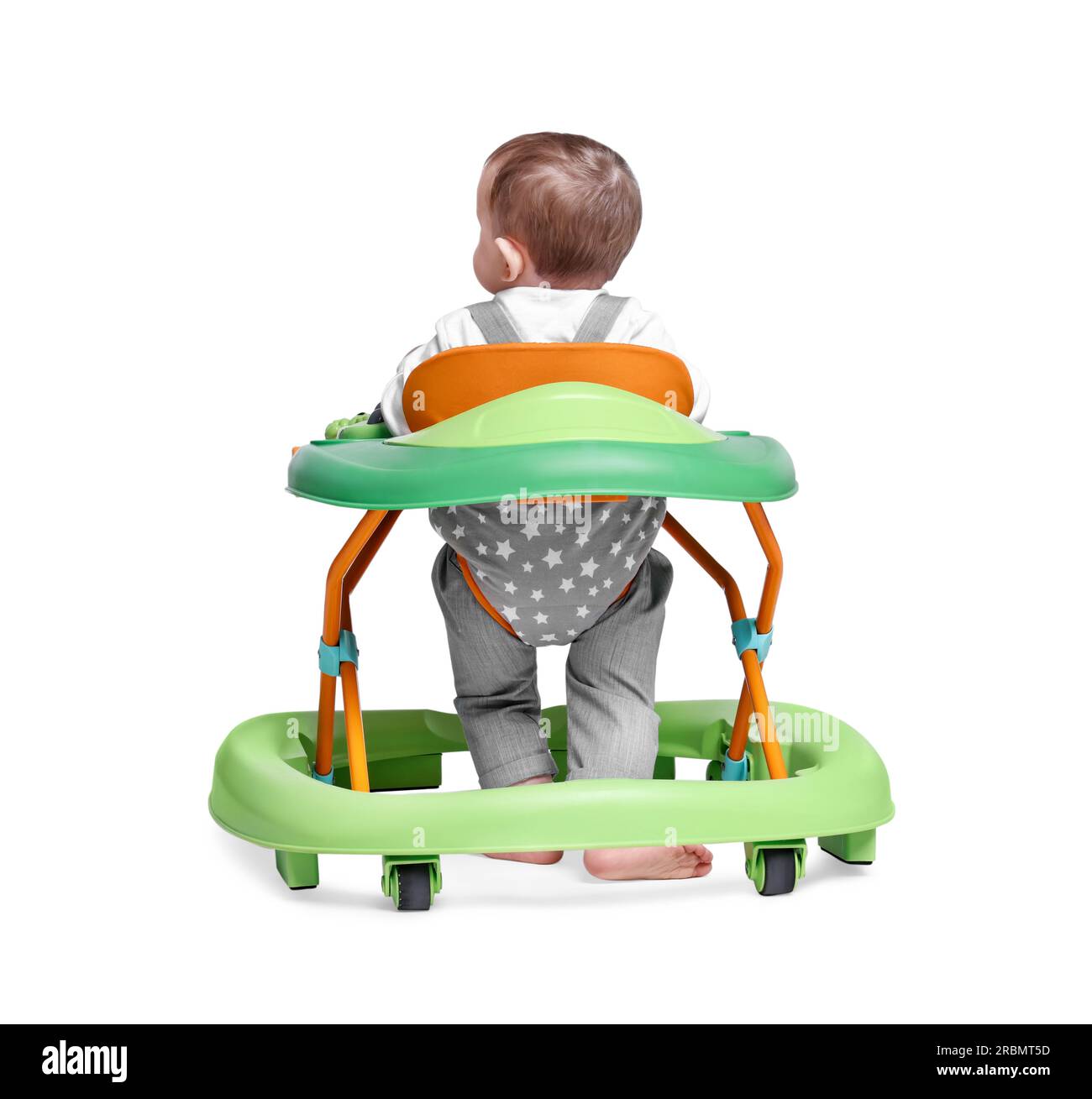 Cute little boy making first steps with baby walker on white background ...