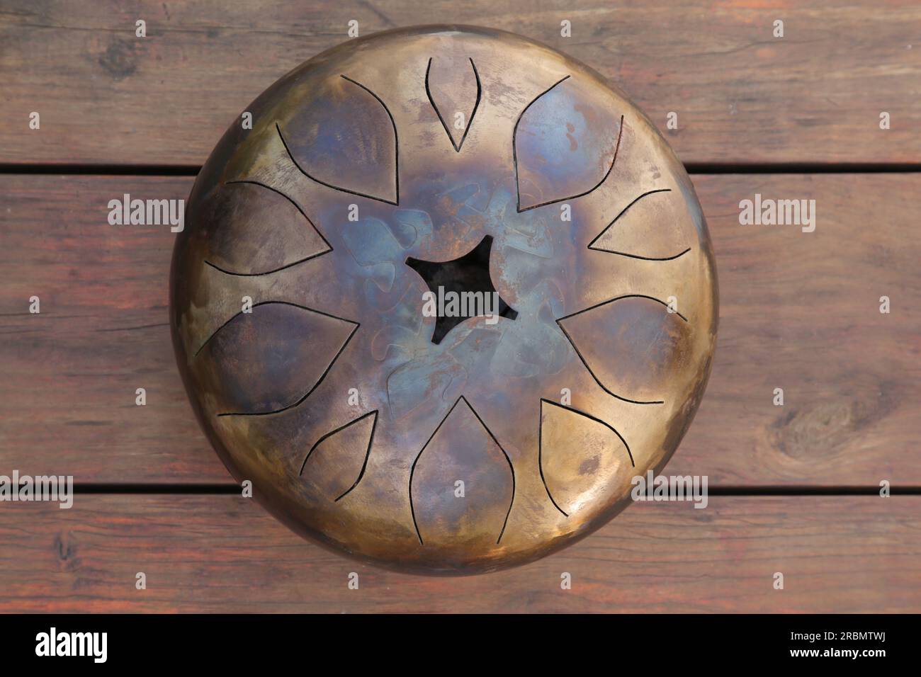 Steel tongue drum on wooden table, top view. Percussion musical ...