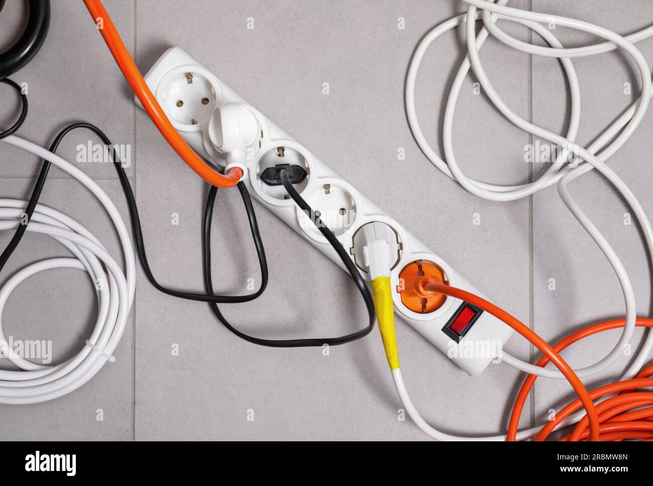 Power strip with electrical plugs on grey floor, flat lay Stock Photo ...