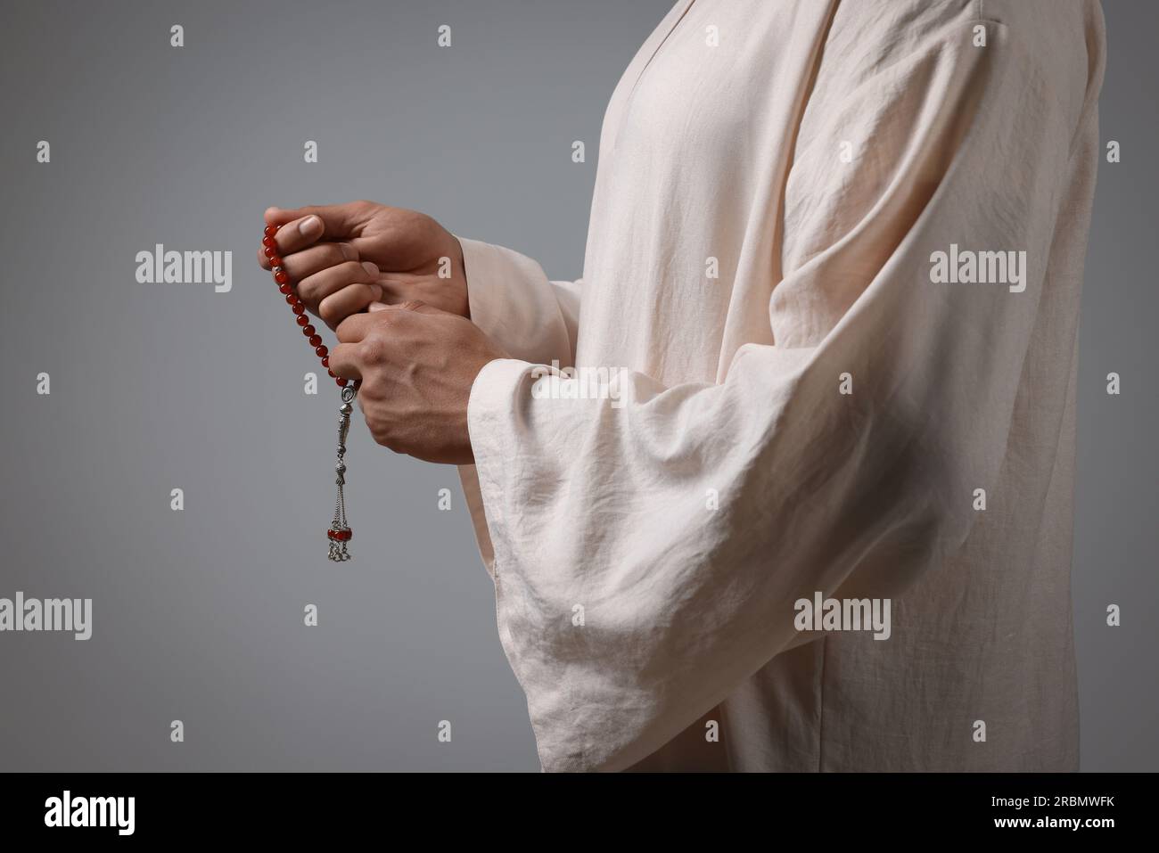 Muslim man with misbaha on light grey background, closeup Stock Photo ...