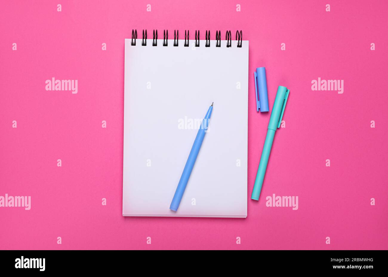 Blank notebook and pens on pink background, flat lay Stock Photo - Alamy