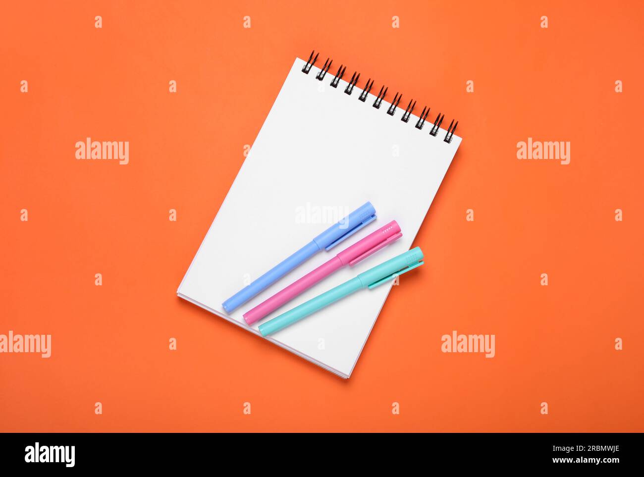 Blank office notebook and pens on orange background, top view Stock ...
