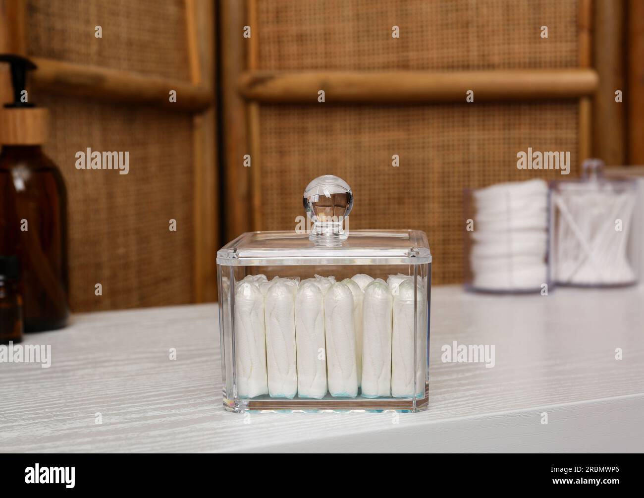 Glass holder with many tampons on white table. Menstrual hygienic ...