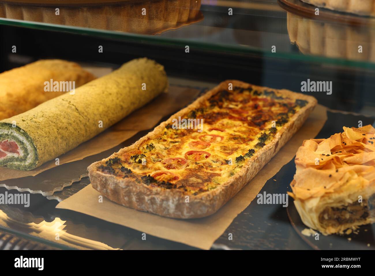 Delicious quiche with cheese and broccoli on counter in bakery shop ...