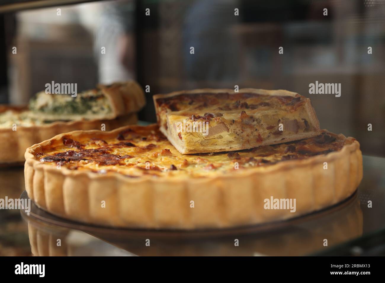 Delicious meat quiche on counter in bakery shop, closeup Stock Photo ...