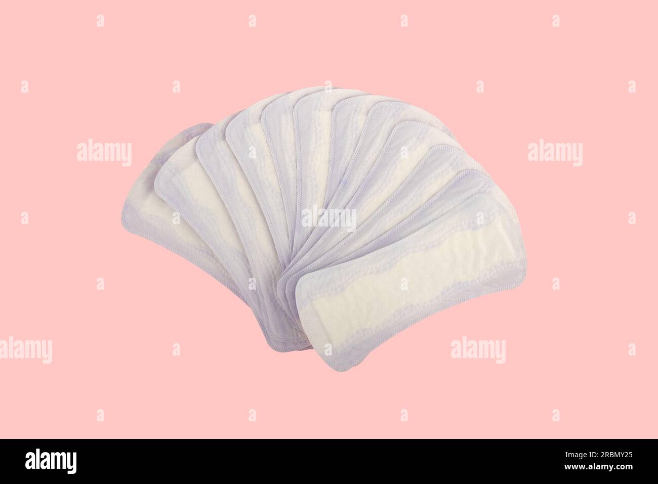 A pack of women's menstrual pads laid out in a fan on a pink background ...