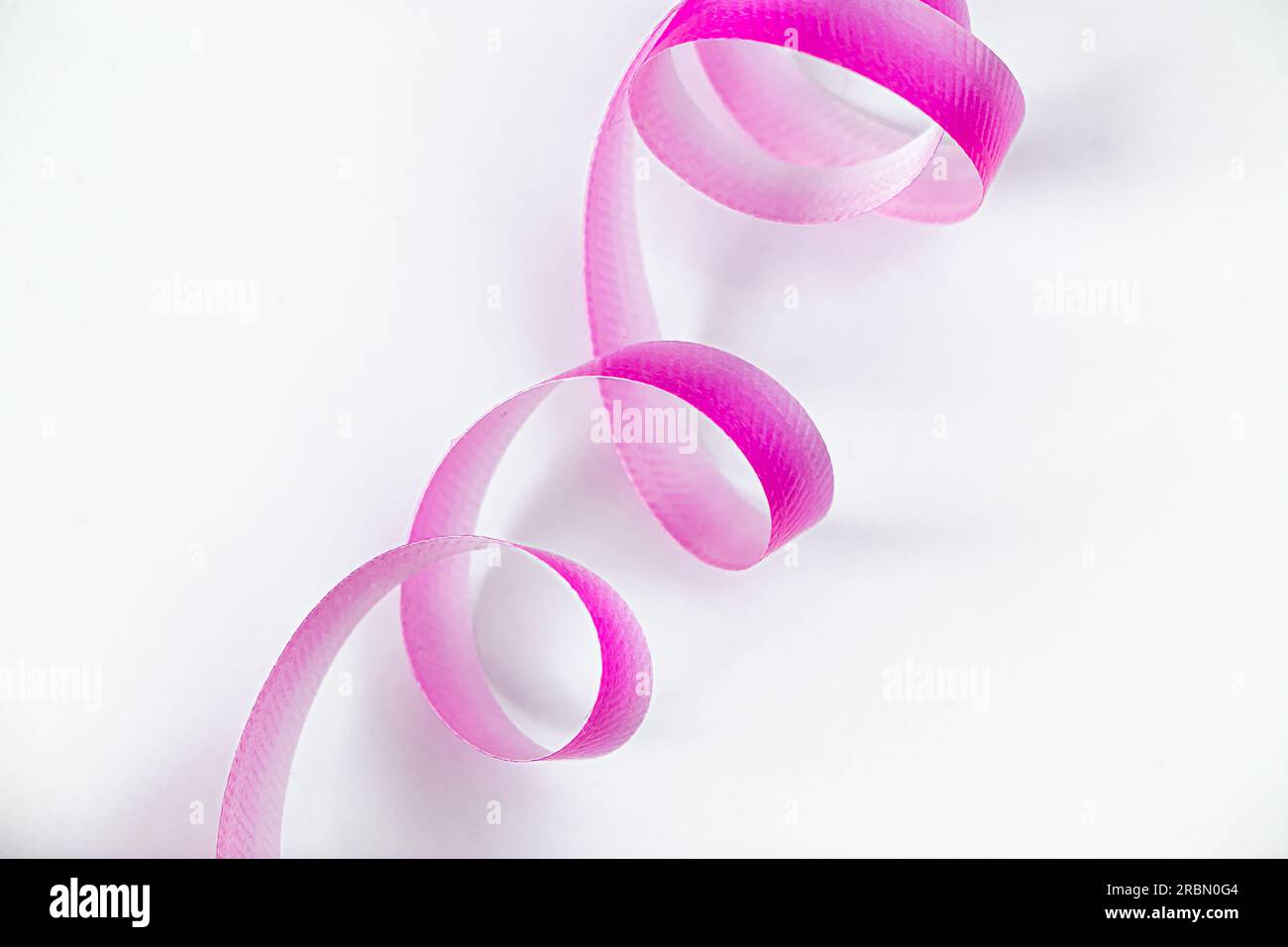 Pink ribbon for wrapping gifts on white background. Curls of decorative ...