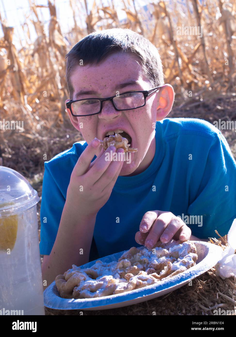Young Boy Eating Funnel Cake Stock Photo - Alamy
