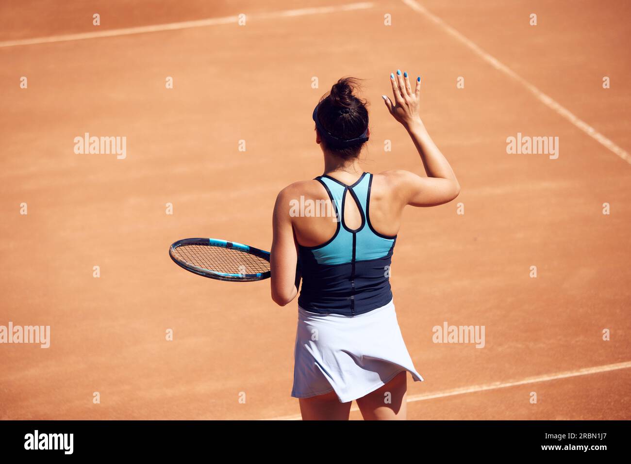 Top back view image of young woman, tennis player staif with racket at ...