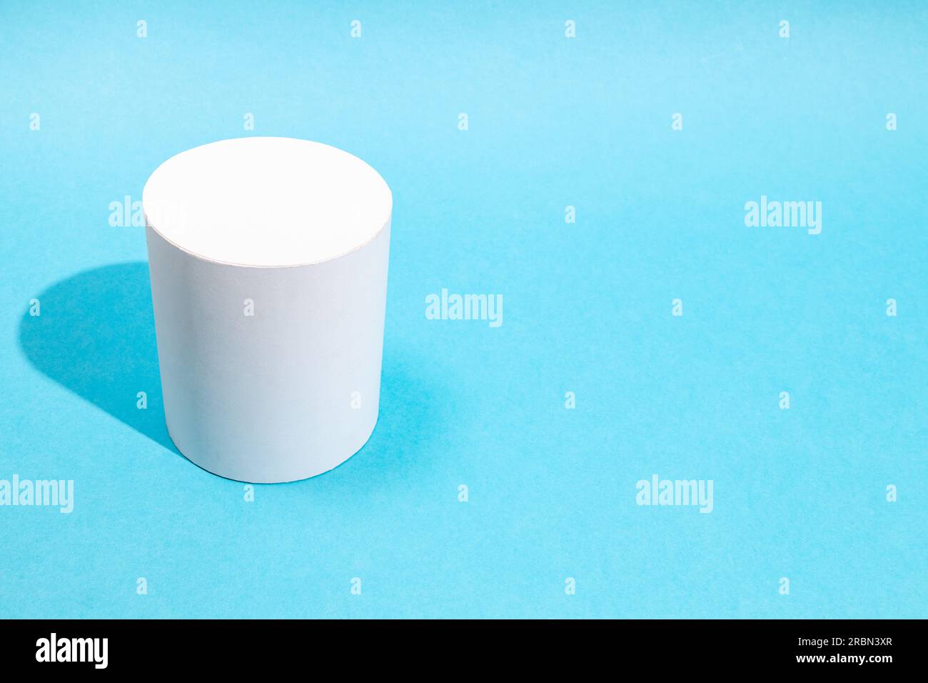 above view of hand-crafted paper cylinder on turquoise blue background ...