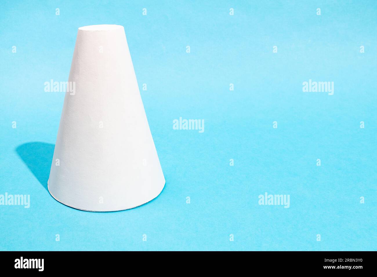 single hand-crafted paper frustum cone on turquoise blue background ...