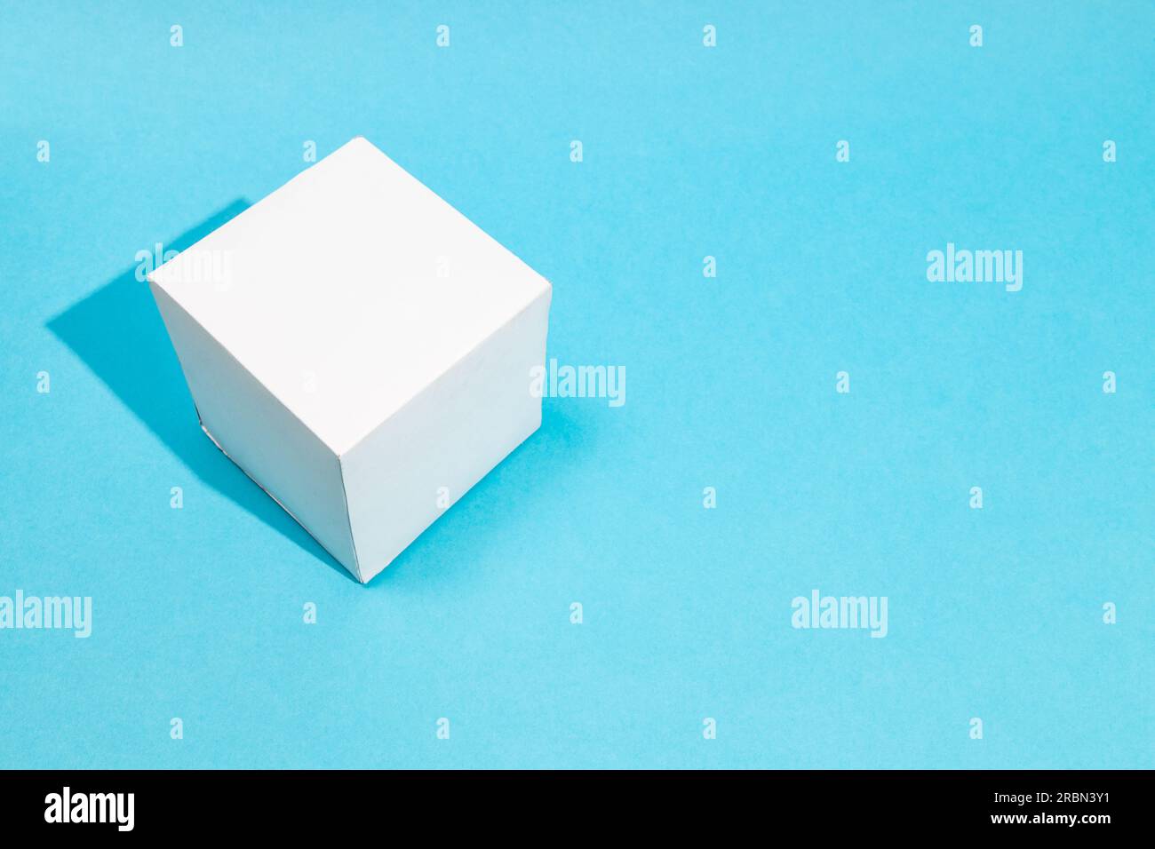 above view of hand-crafted paper cube on turquoise blue background with ...