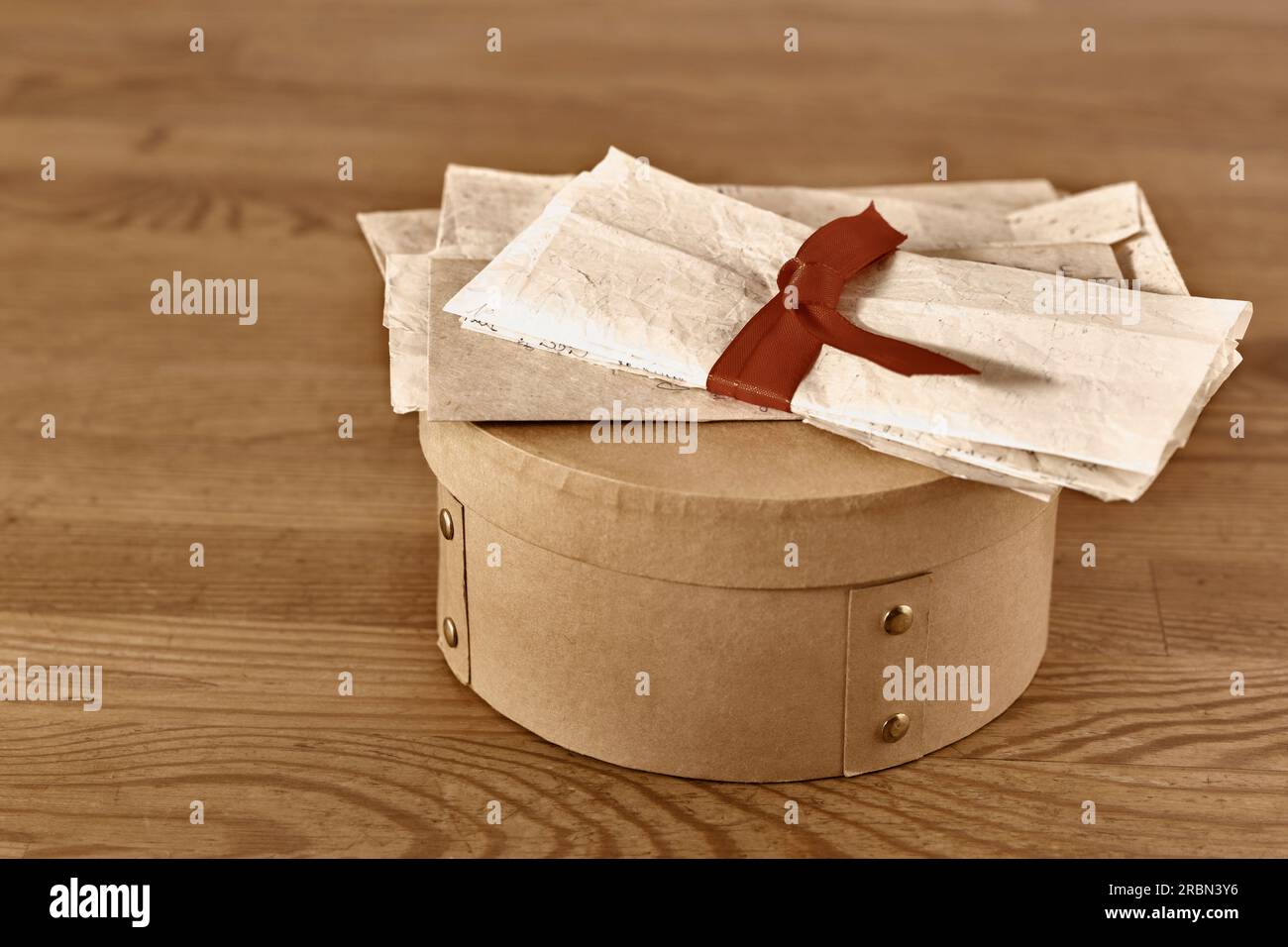Old letters tied with ribbon on box on wooden table , the past memories ...
