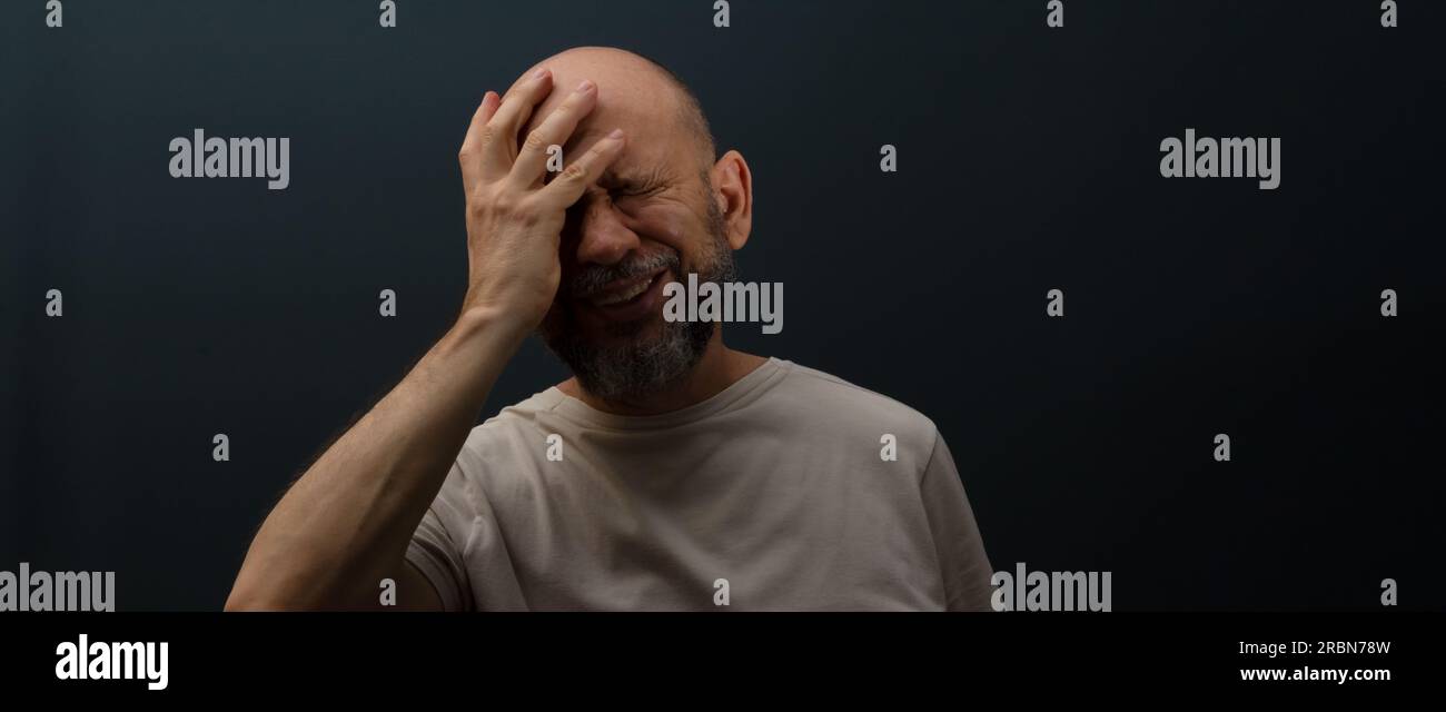 Sad man suffering from headache or migraine. Stressed guy with painful ...