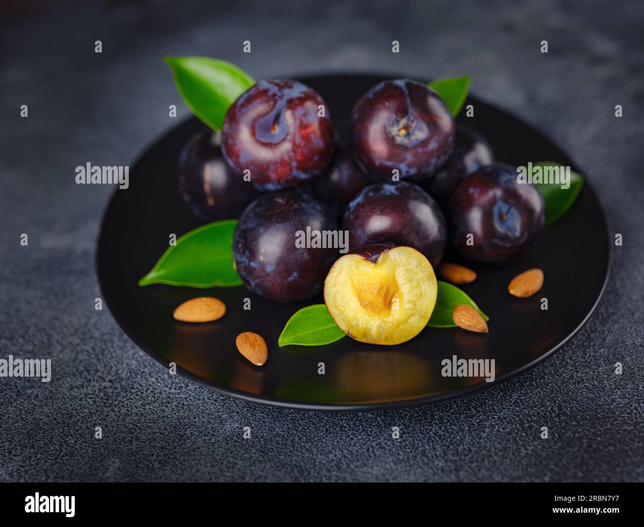 Sweet plums on dark background. Fresh blue plums with leaves. Food ...