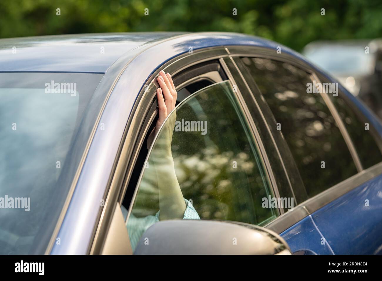 Woman checking hot weather temperature by sticking fingers out of ...