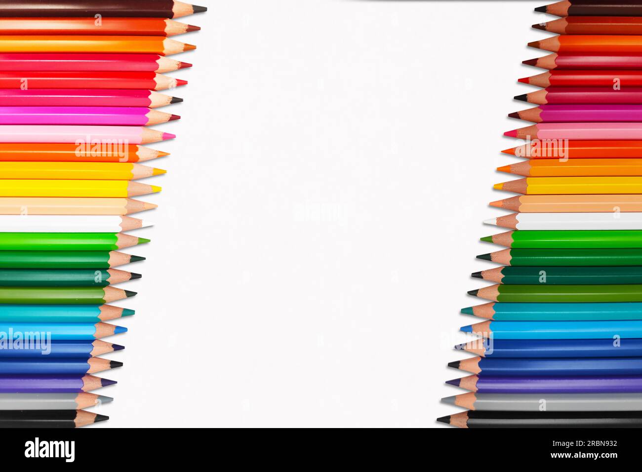 Two rows of crayons in line facing each other on a blank sheet of paper ...