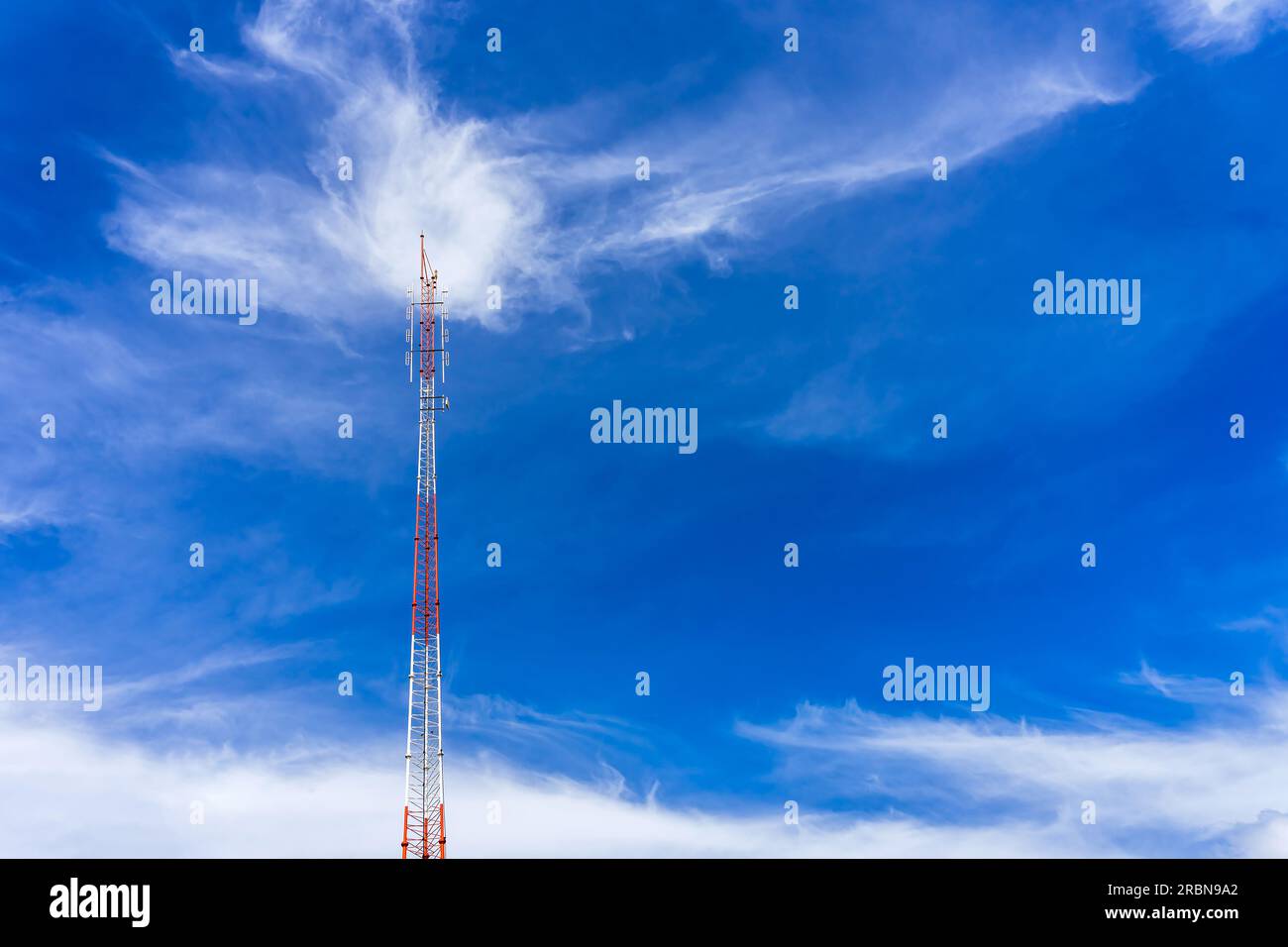 Telecommunication radio wave signal tower red and white with cloudy. Steel truss of transmission ...