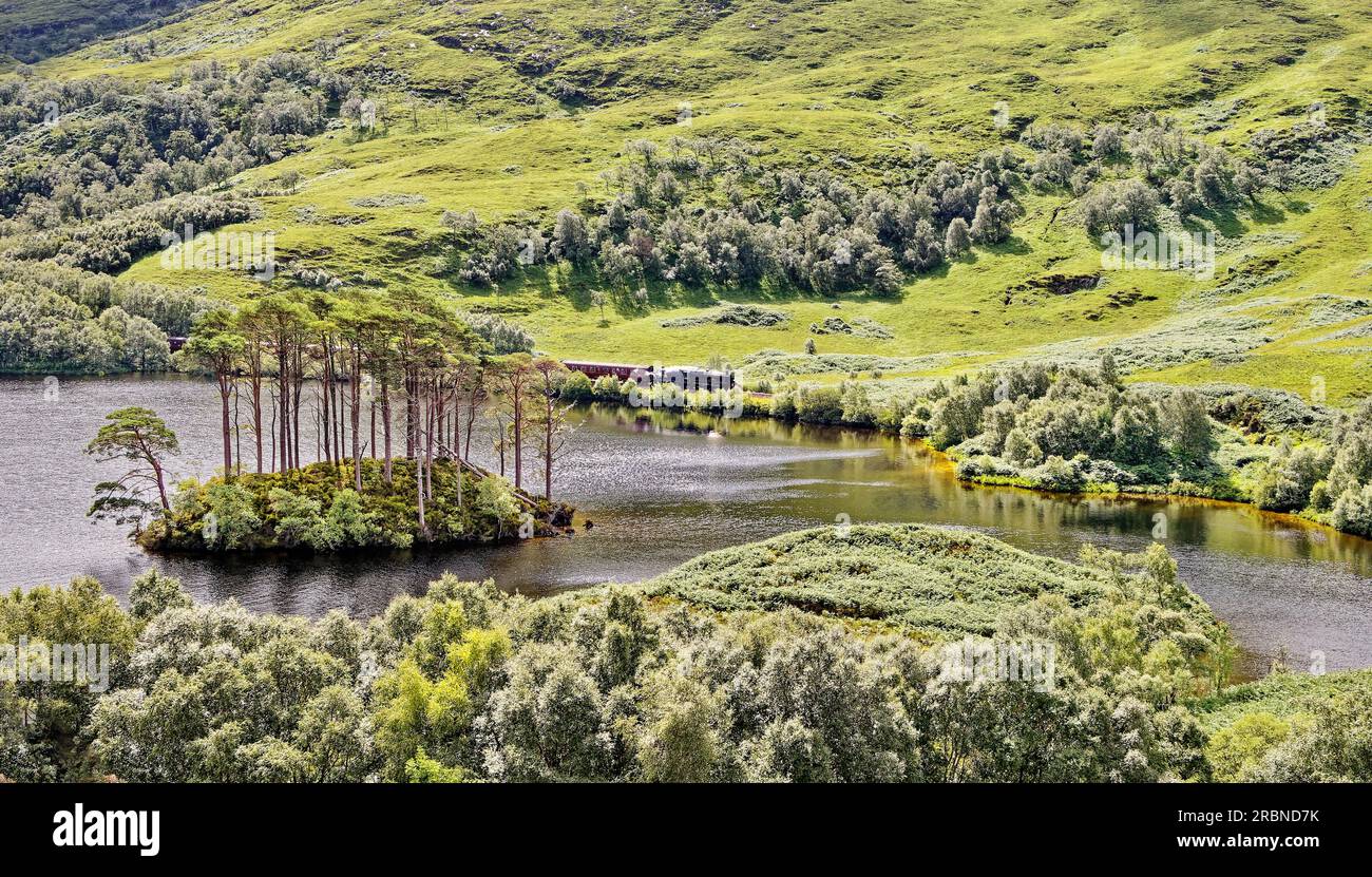 Jacobite Steam Train on the track alongside Loch Eilt and the island ...