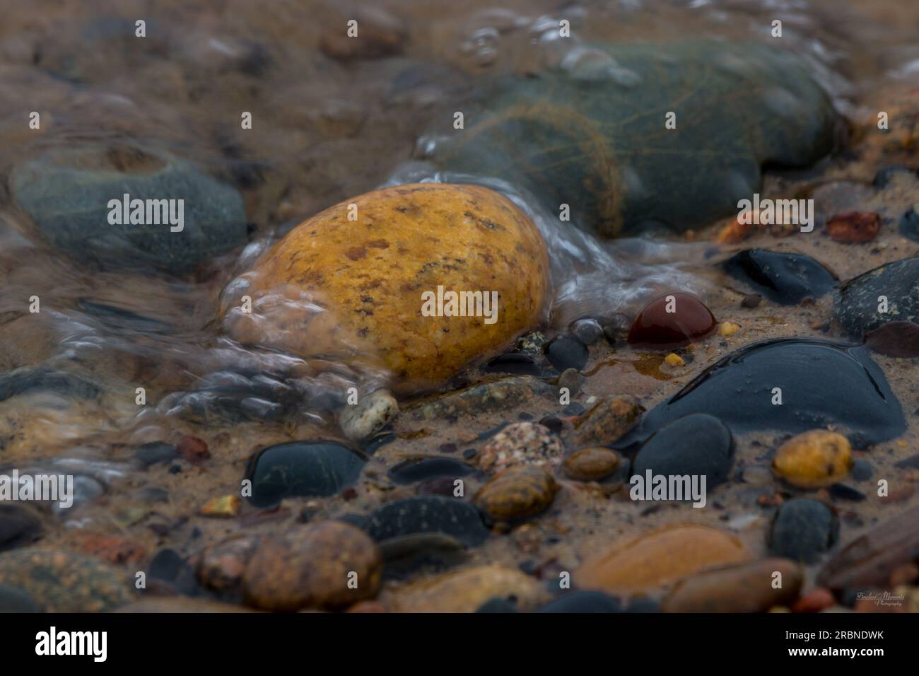 A capture of water flowing over some rocks along the Whitefish Point ...