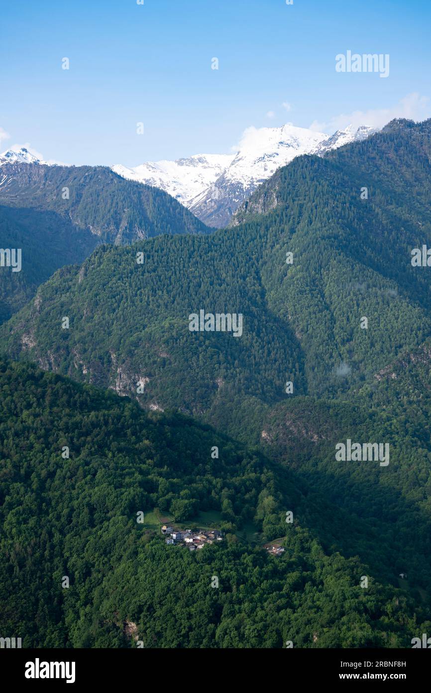 A picturesque village rests amidst the lush forests, verdant mountains ...