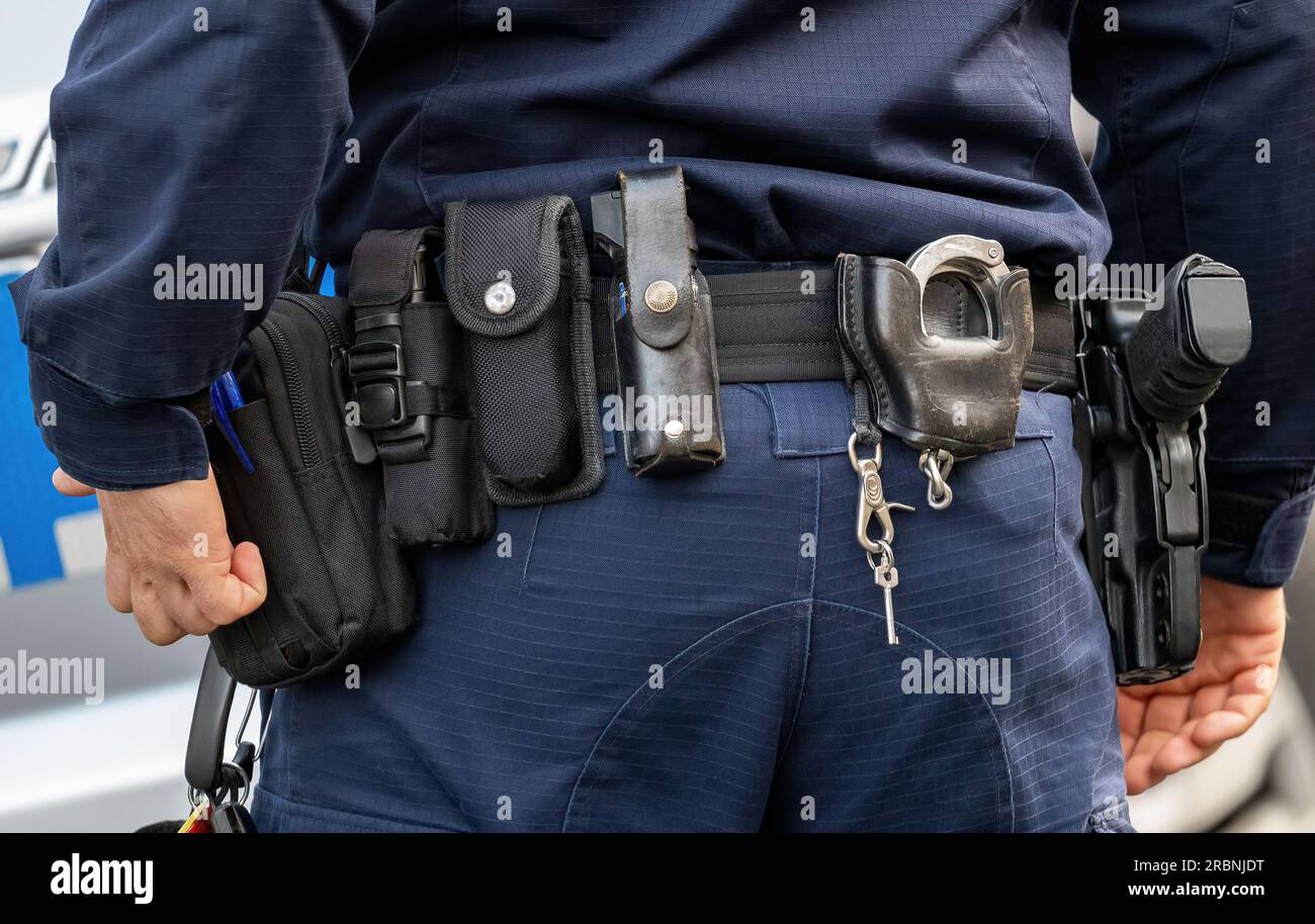Policeman, police equipment utility belt with a gun, pepper spray and ...