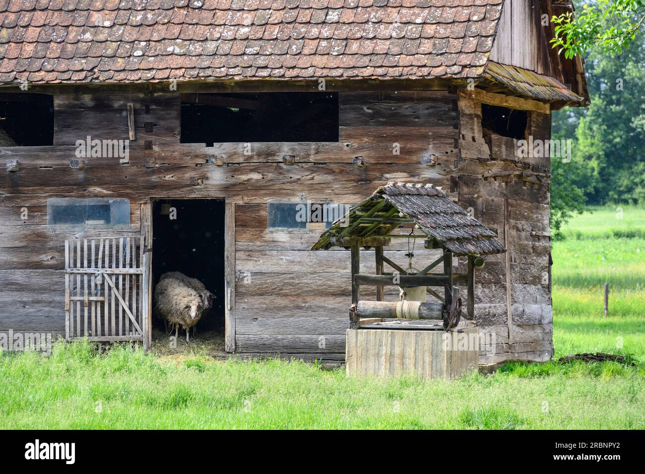 A farm yard with traditional wooden barn and well in the village of ...