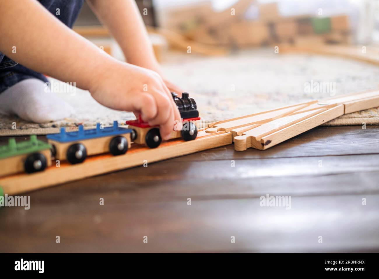 Close-up of children's hands playing with trains. The kid spends time ...