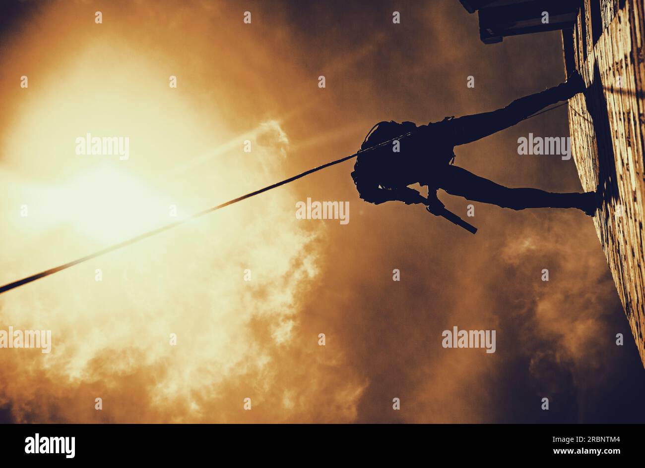 Silhouette of police officer in tactical gear descending from a height ...
