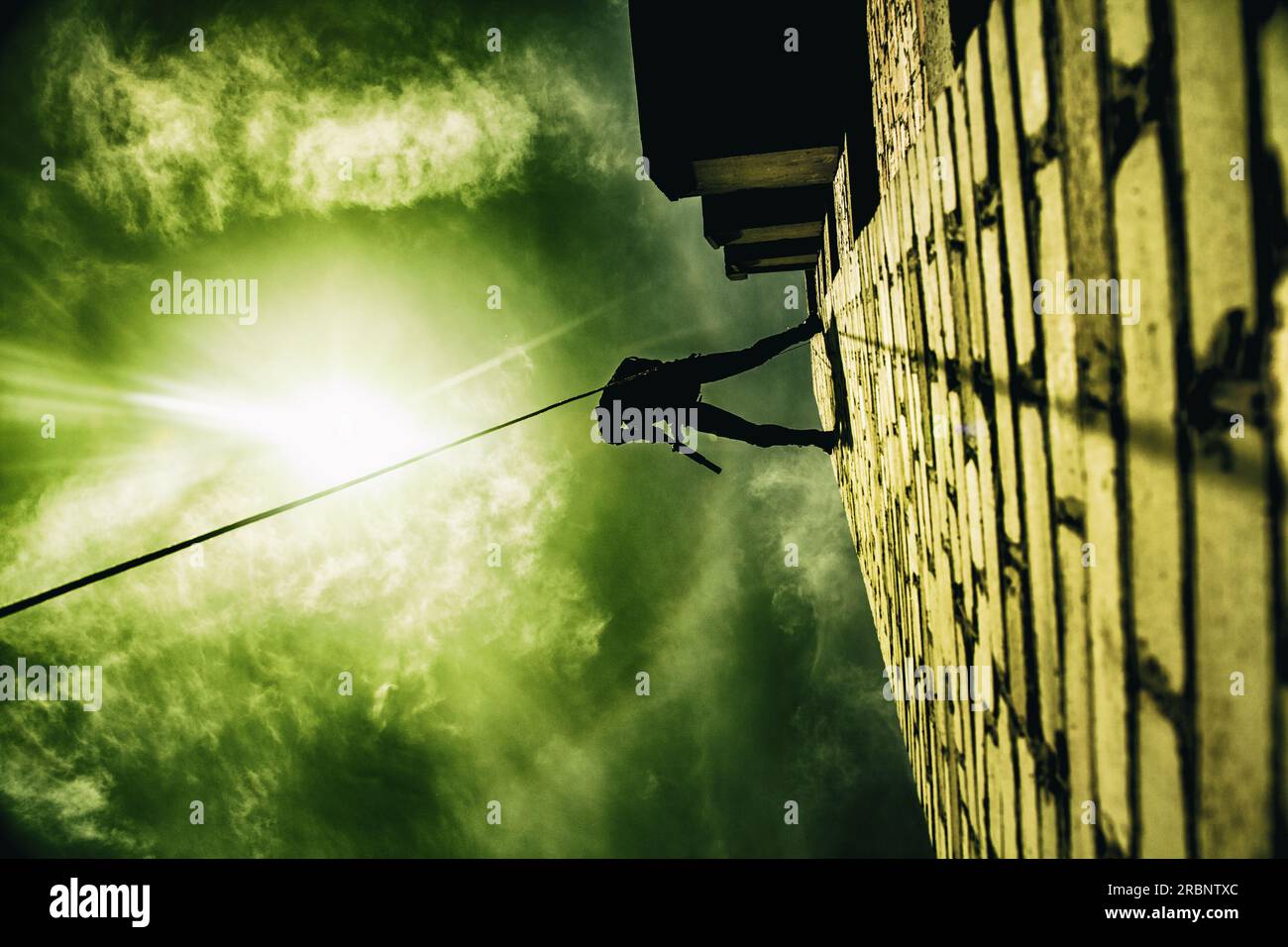 Silhouette of police officer in tactical gear descending from a height ...