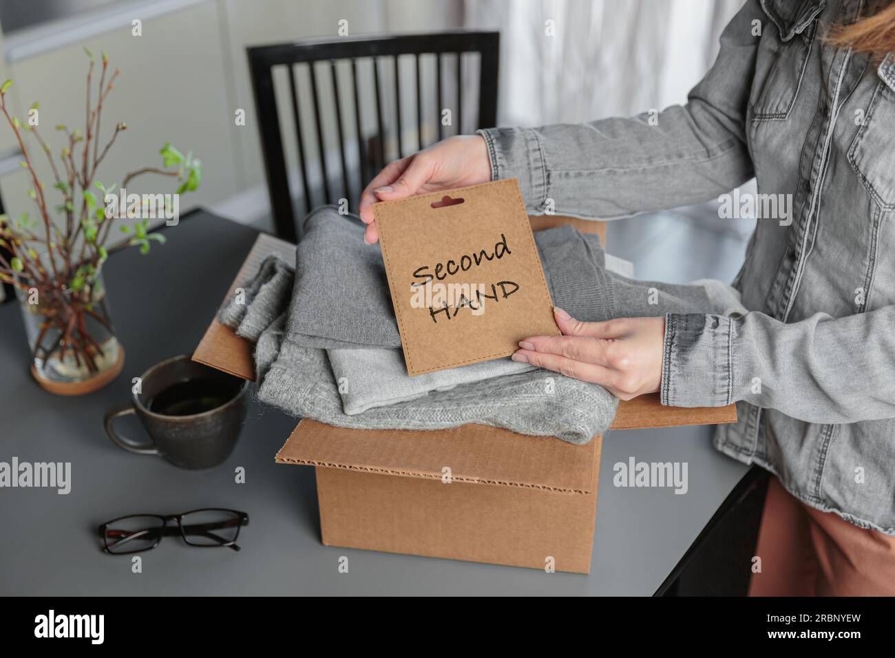 Woman packing box with used clothes for resale Stock Photo - Alamy
