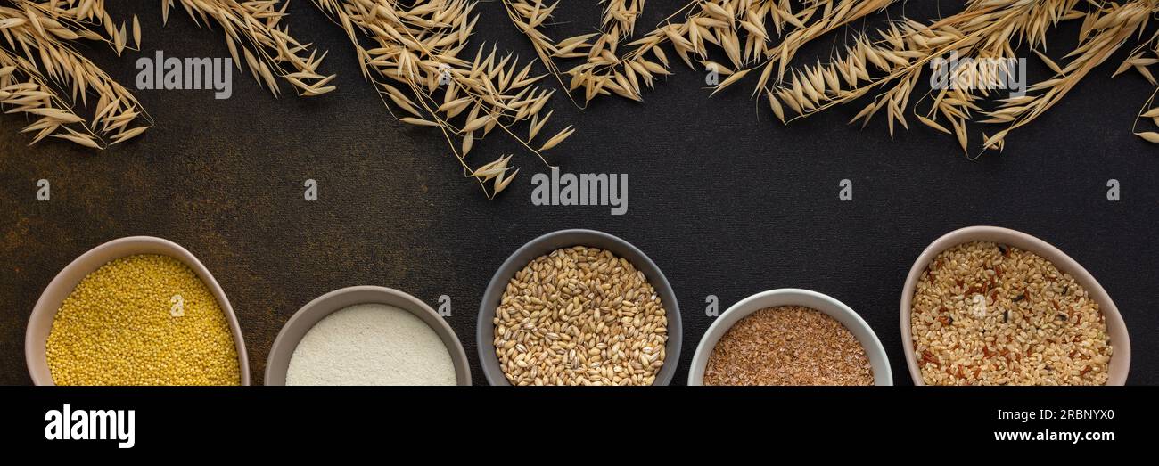 Various grain cereals in bowls banner, top view on a brown background ...