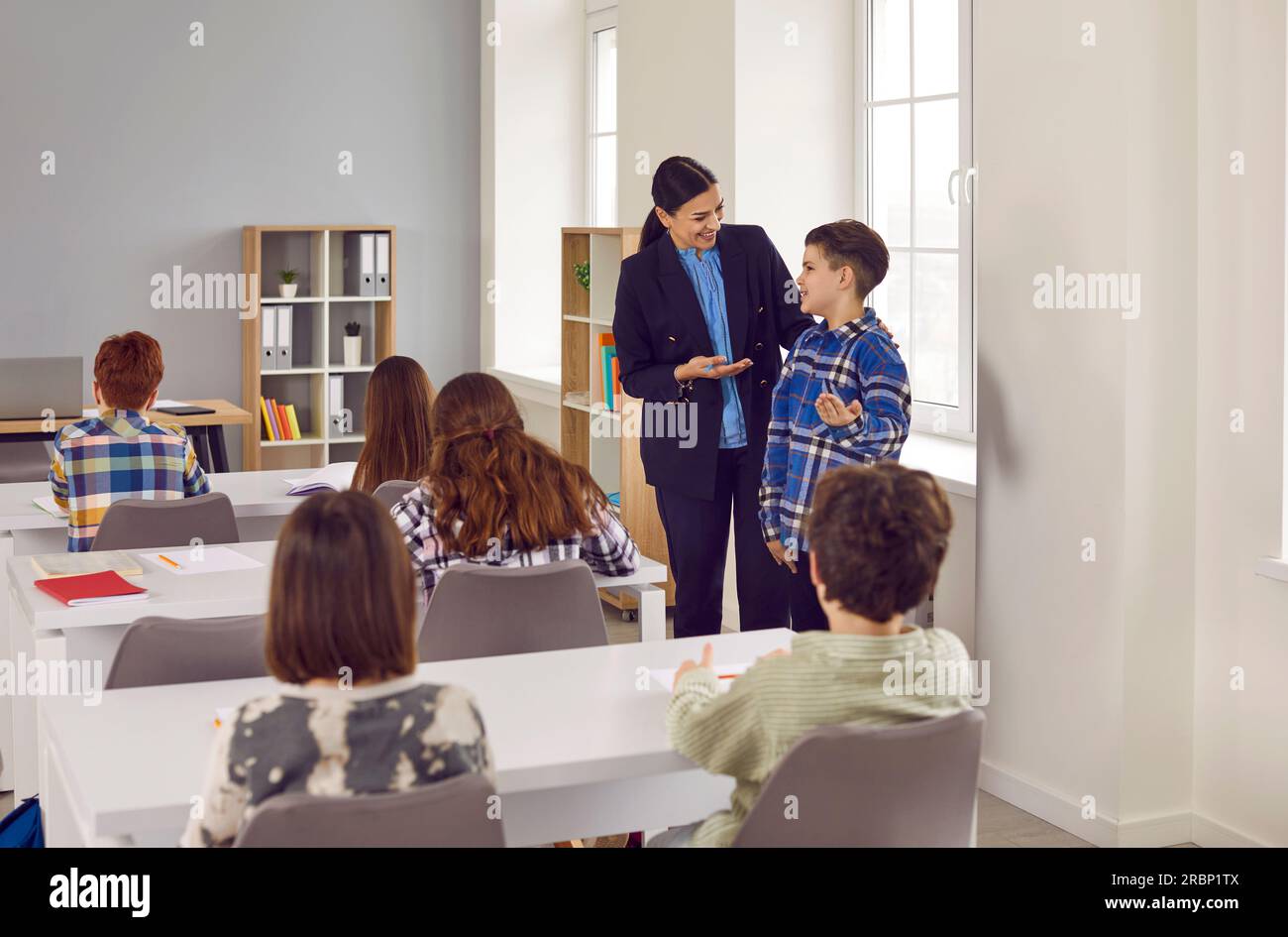 Young schoolboy answering a teacher on a lesson standing in the ...