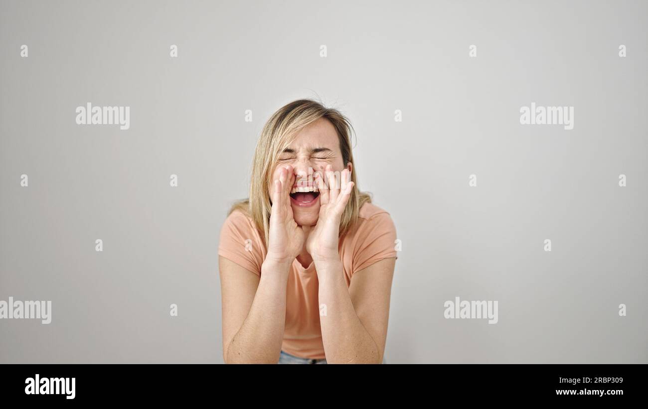 Young blonde woman screaming over isolated white background Stock Photo ...