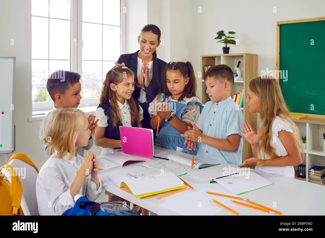 Happy multiethnic children with woman teacher have good time at school ...