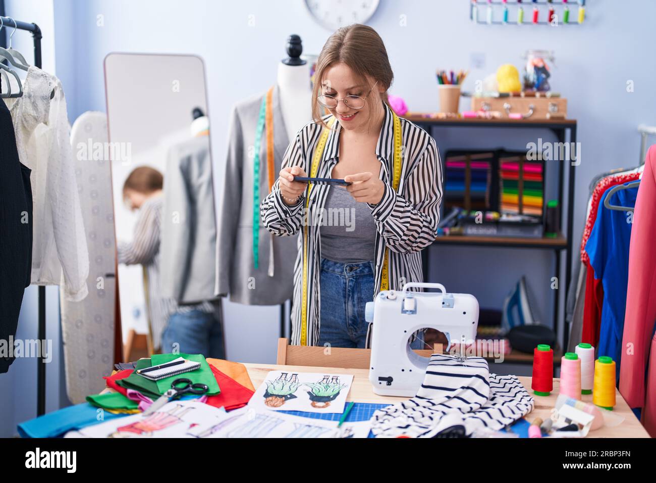 Young blonde woman tailor make photo to clothing design at tailor shop ...