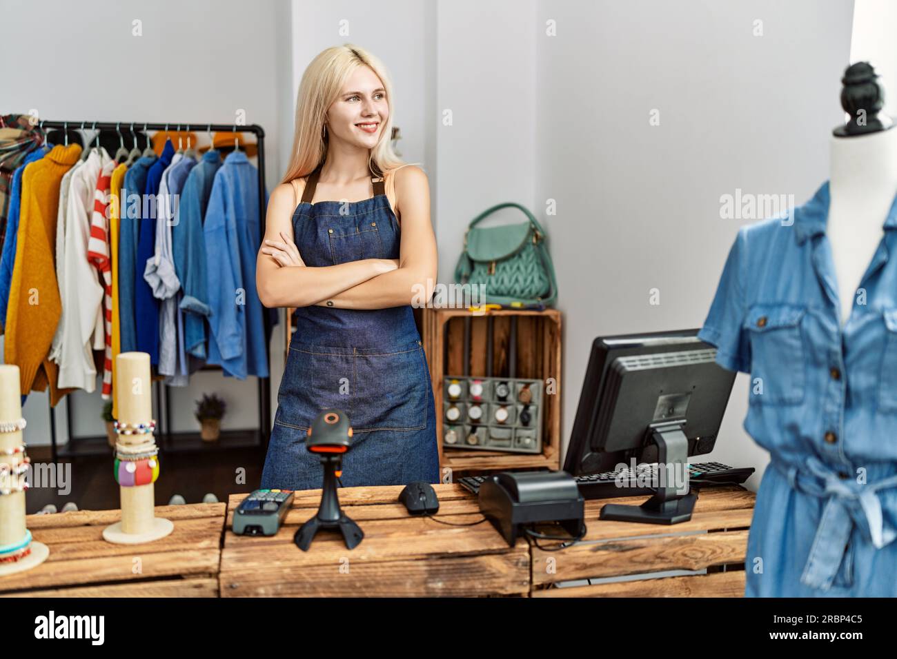 Young blonde woman shop assistant standing with arms crossed gesture ...