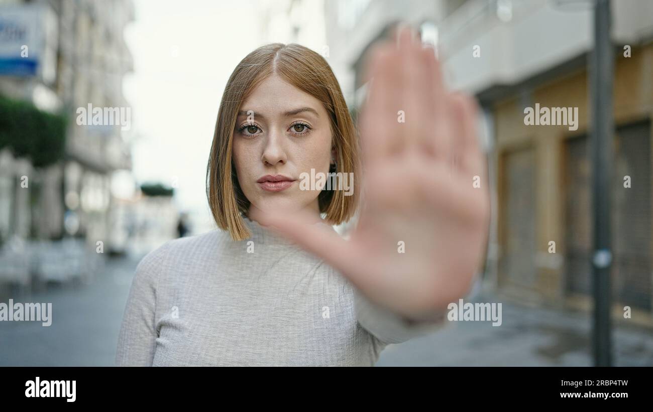 Young blonde woman doing stop gesture with hand at street Stock Photo ...
