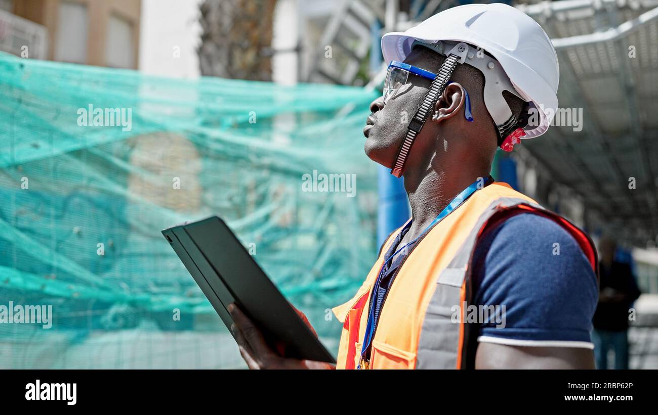 African american man builder using touchpad looking around at ...