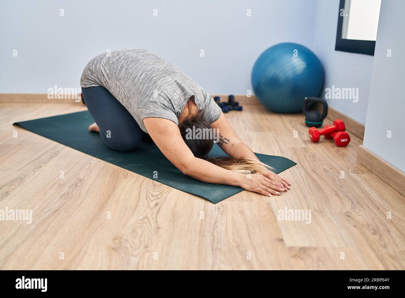 Young beautiful plus size woman stretching back at sport center Stock ...