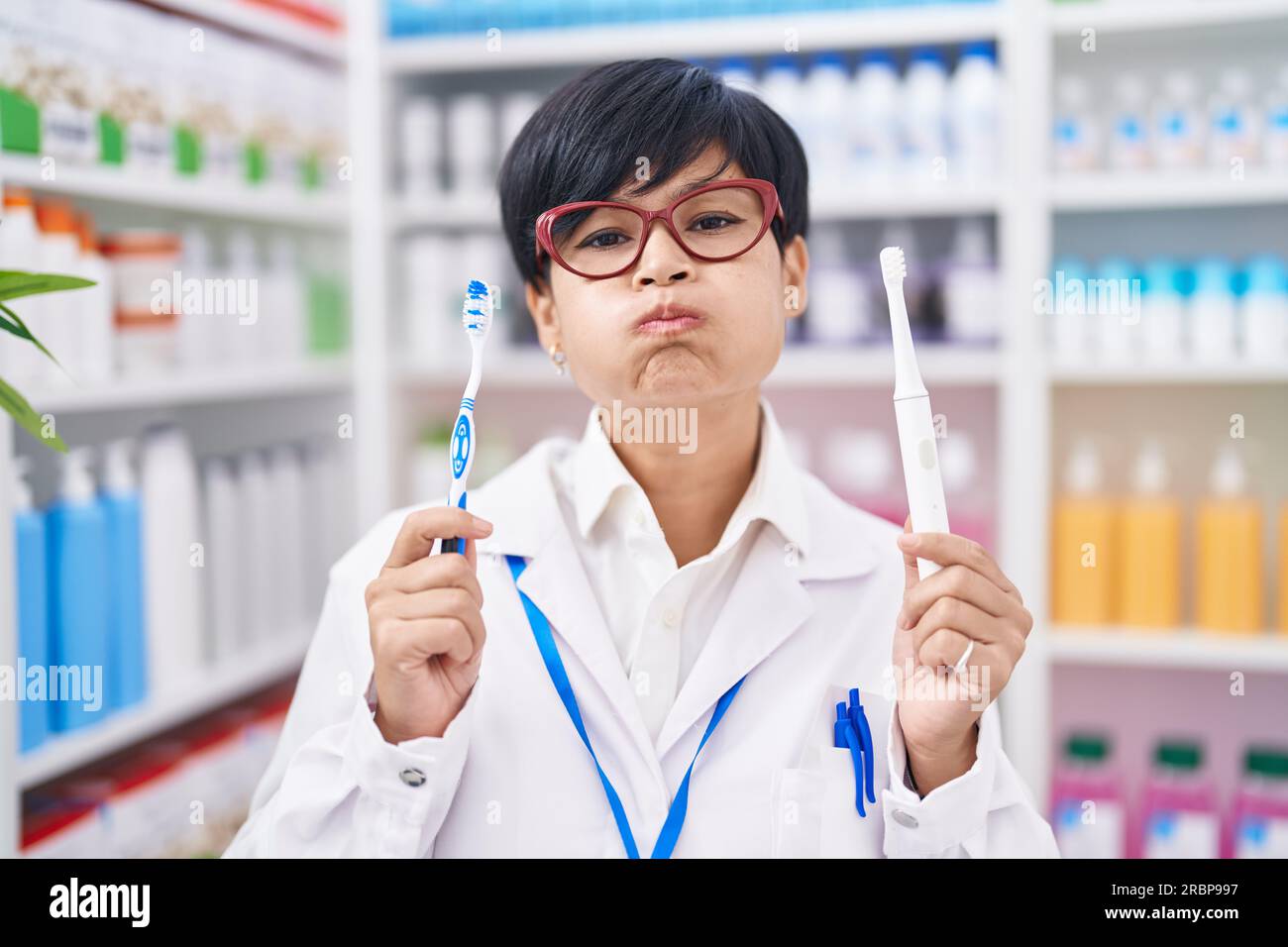 Young asian woman with short hair doing toothbrush comparative at ...