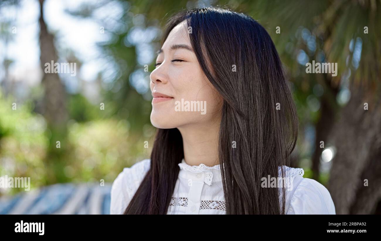 Young chinese woman breathing with closed eyes at park Stock Photo - Alamy
