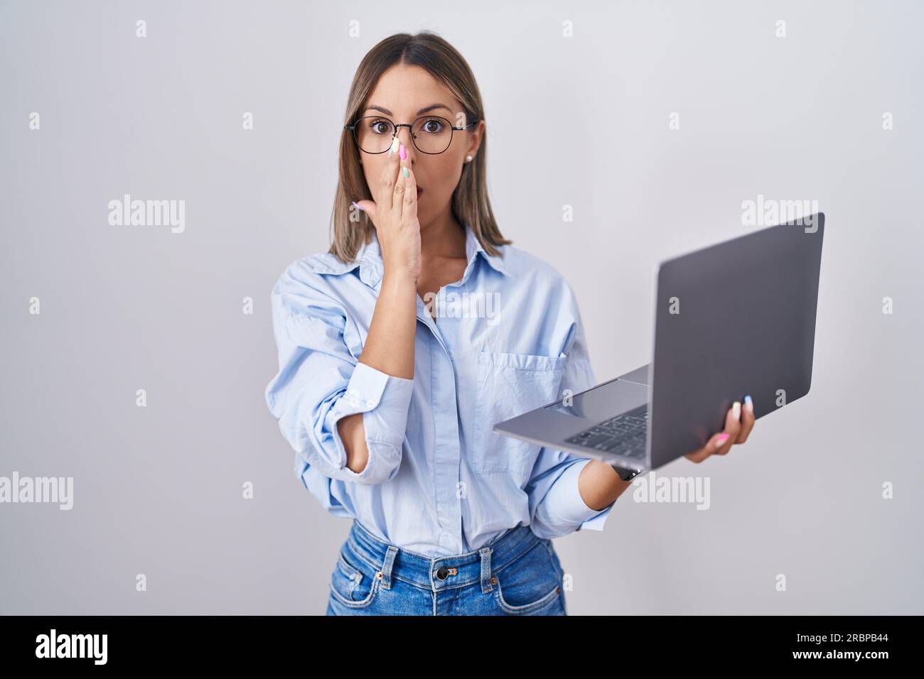 Young woman working using computer laptop afraid and shocked, surprise ...